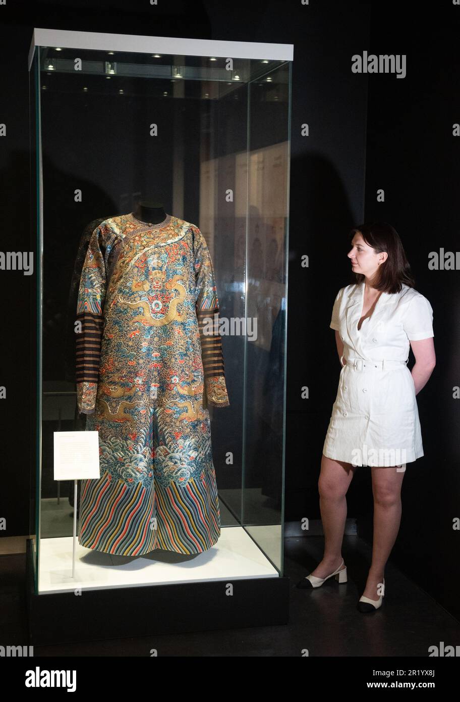 A British Museum worker looks at an Imperial blue robe during a photo ...