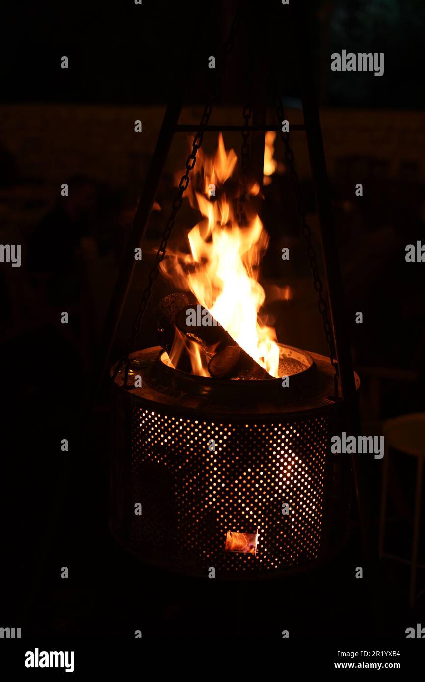 A roaring campfire burning in an open flame pit, with a plethora of ...