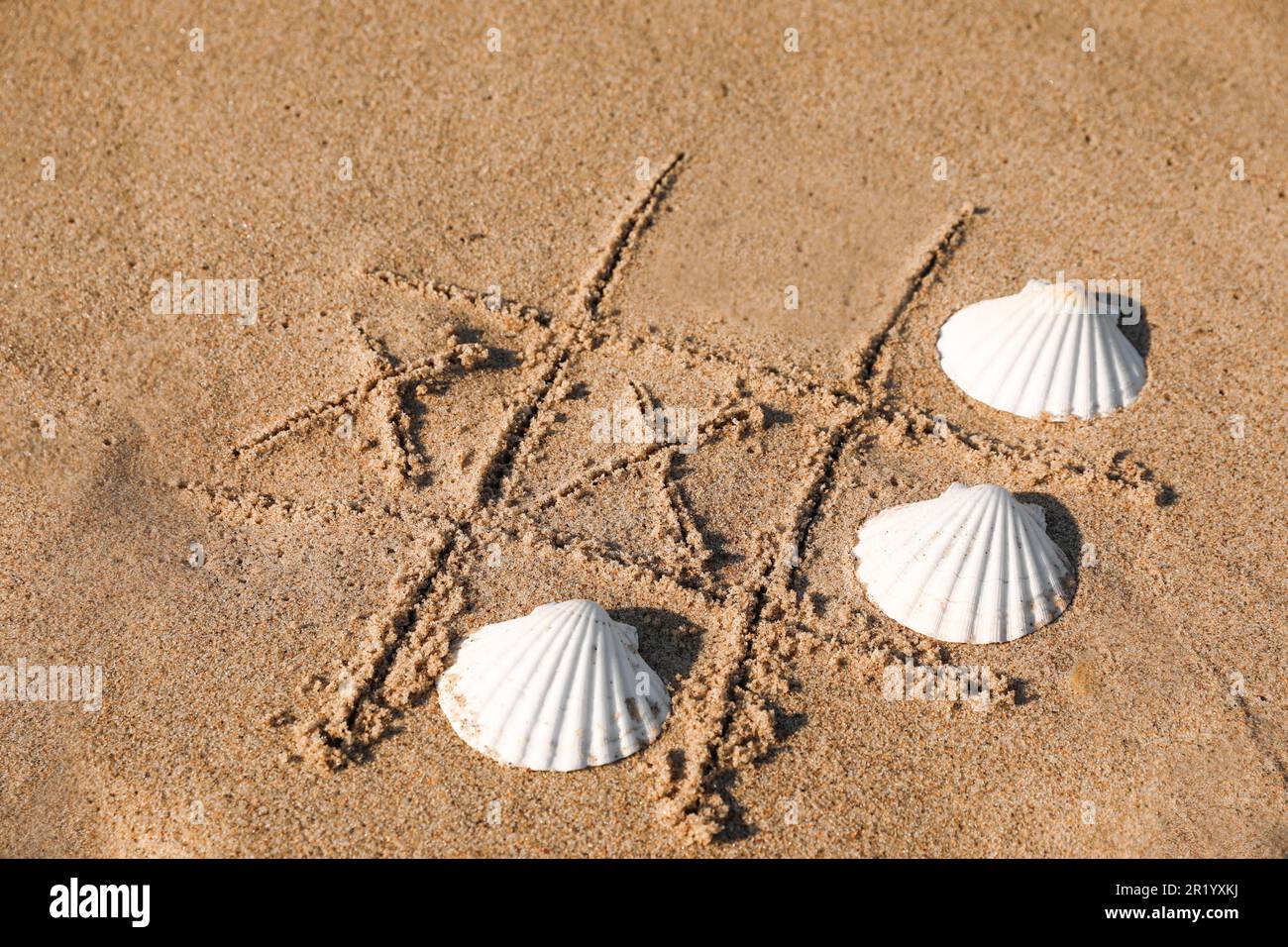 Playing Tic tac toe game with shells on sand Stock Photo - Alamy