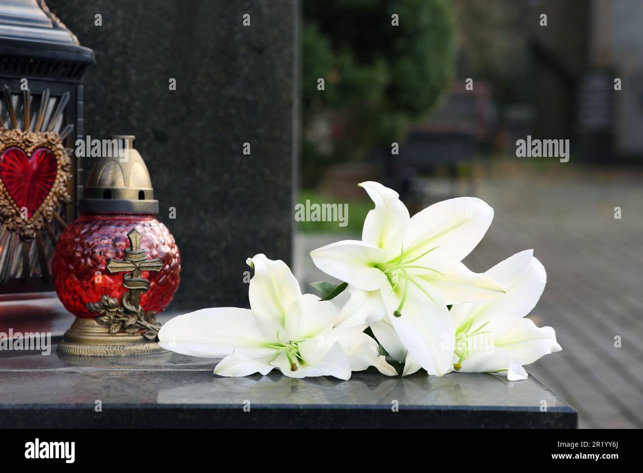 White lilies and grave light on grey granite tombstone outdoors. Funeral ceremony Stock Photo ...