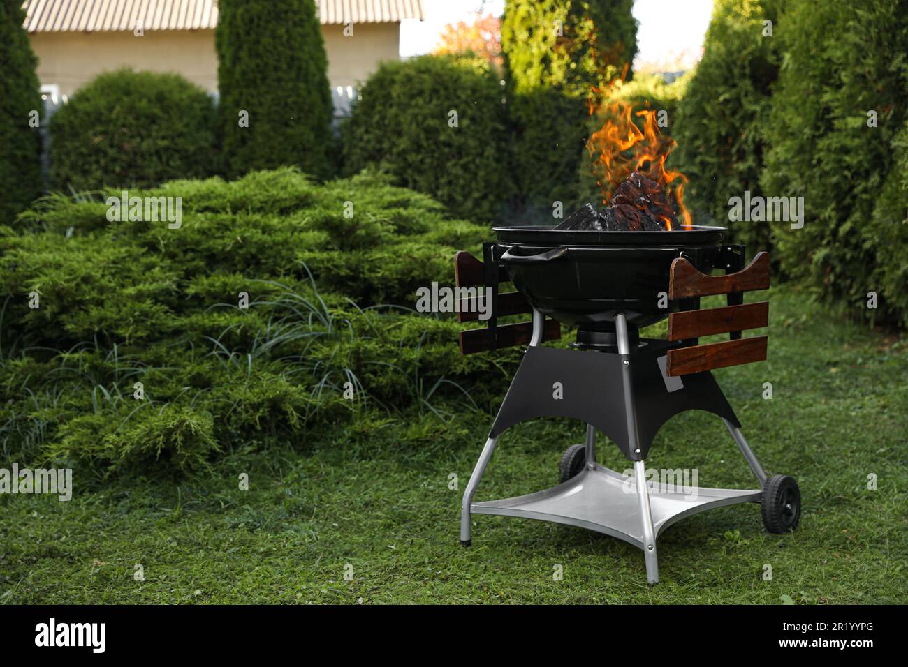 Portable barbecue grill with fire flames outdoors. Space for text Stock ...