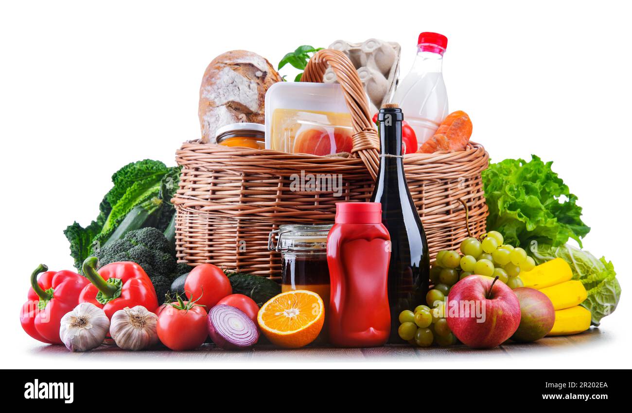 Wicker basket with assorted grocery products including fresh vegetables ...
