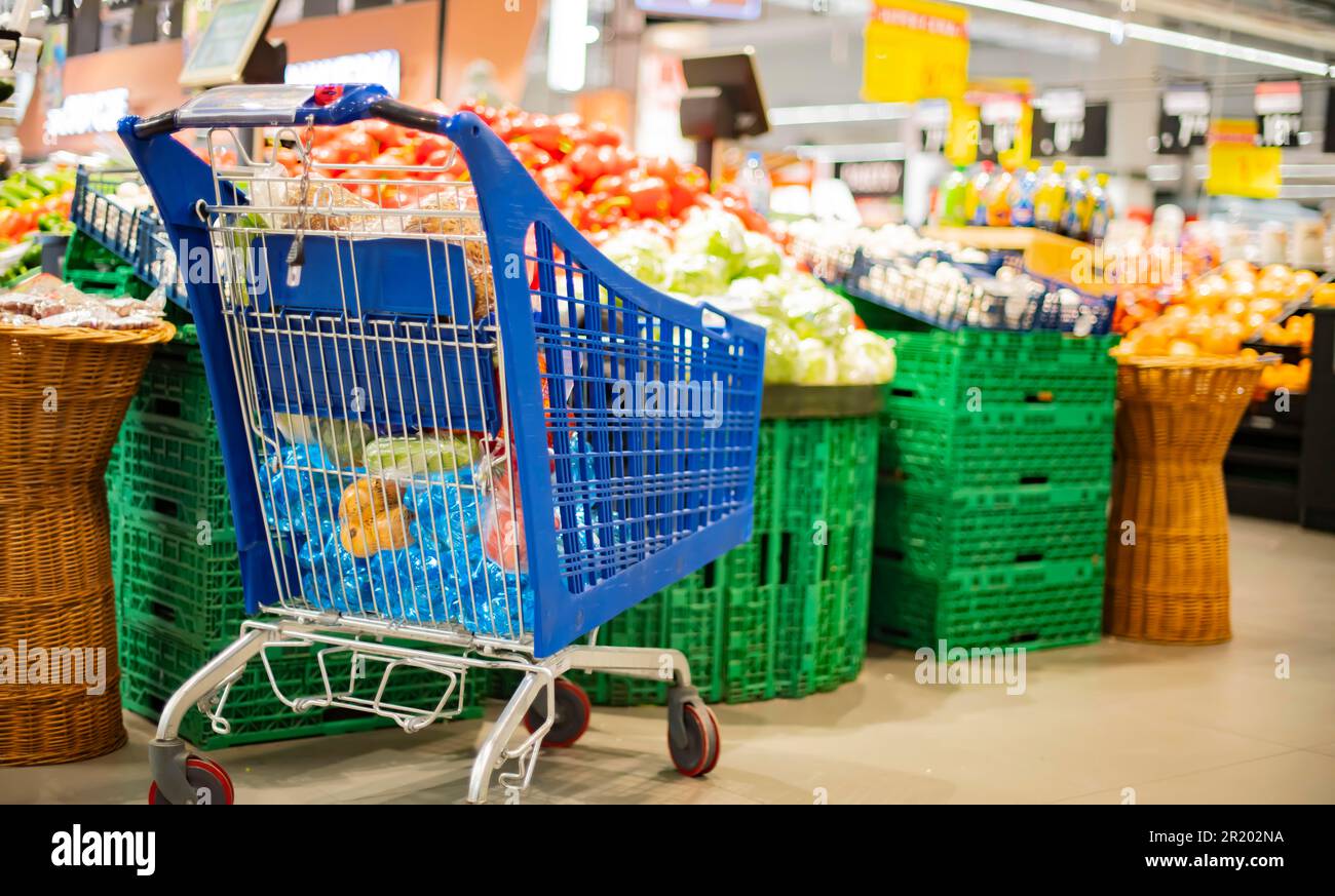 A shopping cart with grocery products in a supermarket Stock Photo - Alamy