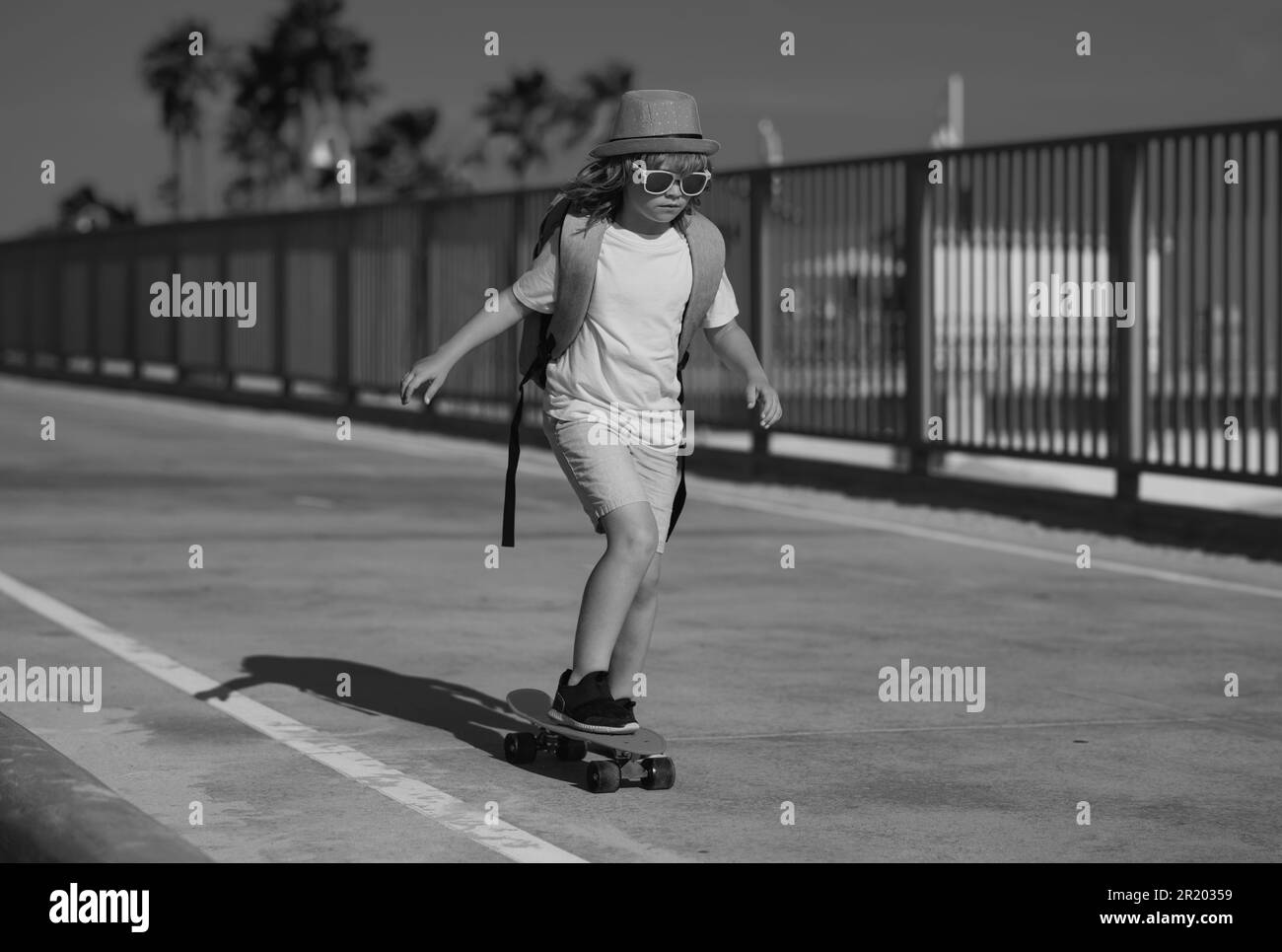 Child riding skateboard in summer park. Little boy learning to ride ...