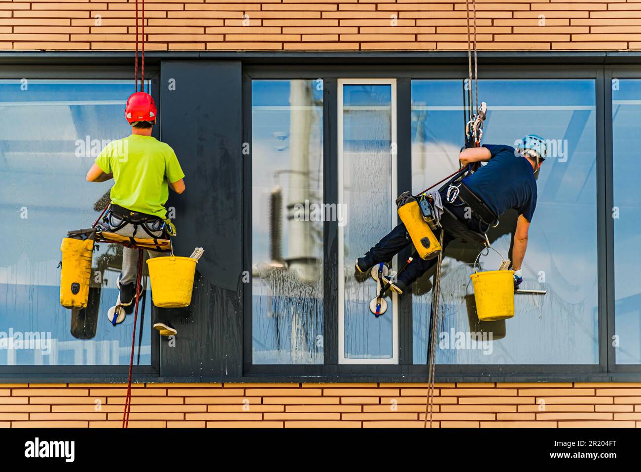 Two men cleaning windows on an office building Stock Photo - Alamy