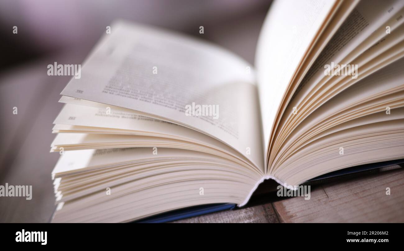 Composition with open book on the table Stock Photo - Alamy