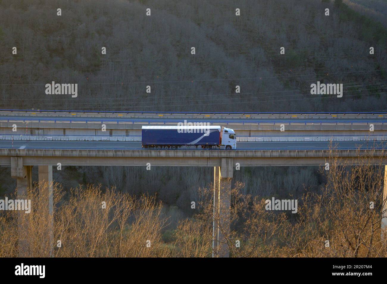 Goods truck crossing a highway bridge at sunset horizontal Stock Photo ...