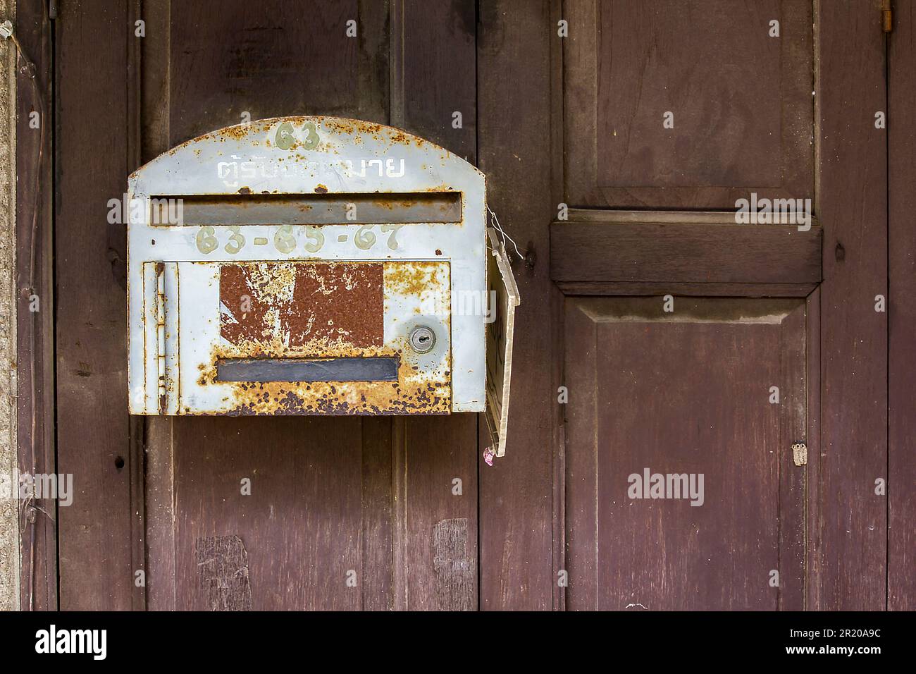 Old gray letter box on brown wood wall Stock Photo - Alamy