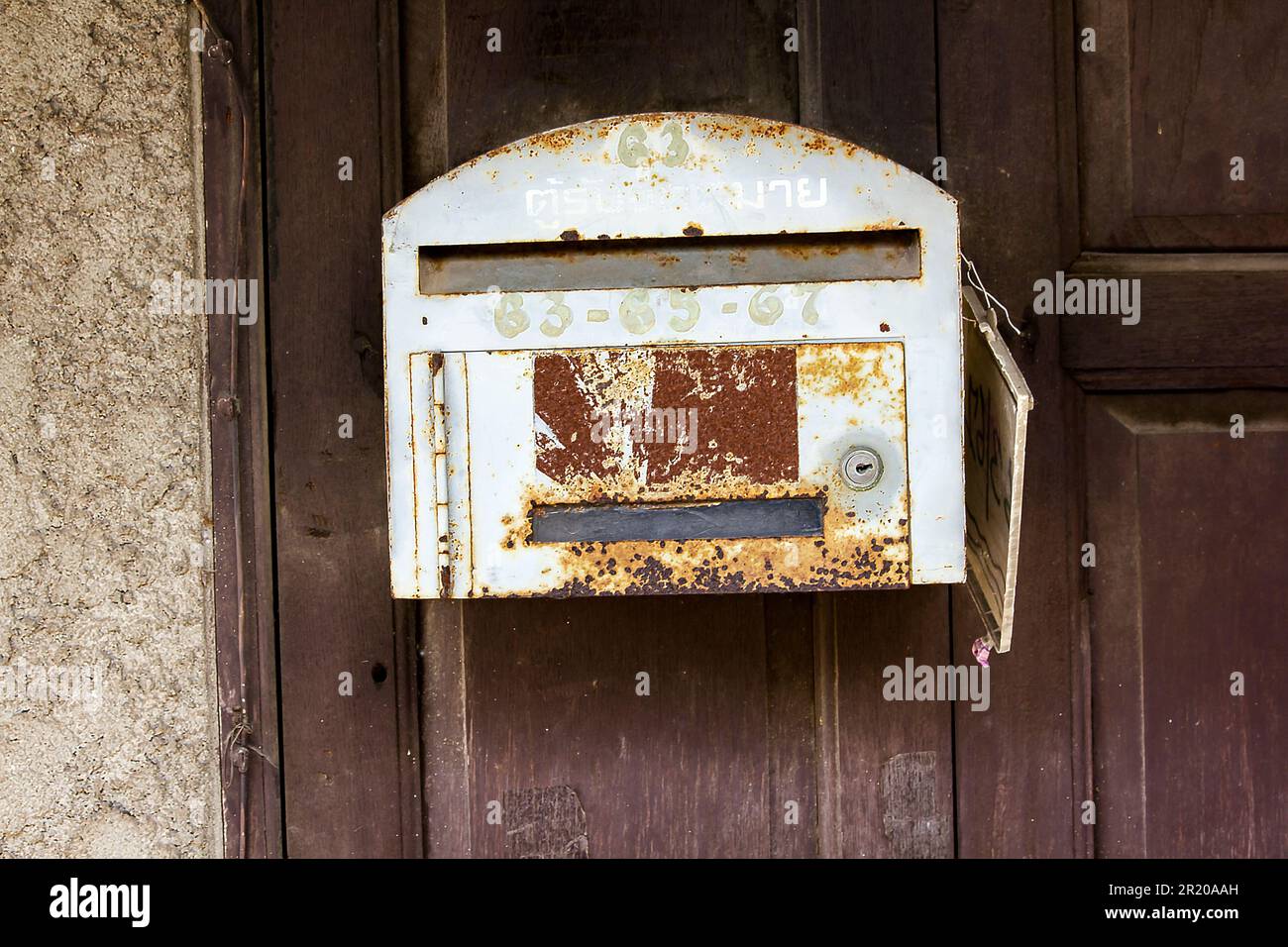 Old gray letter box on brown wood wall Stock Photo - Alamy