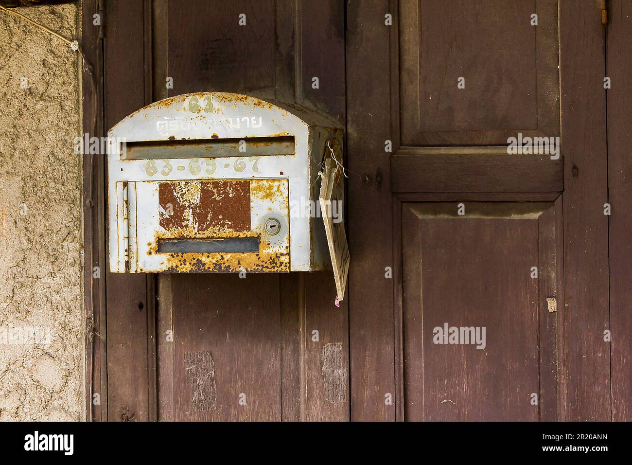 Old gray letter box on brown wood wall Stock Photo - Alamy