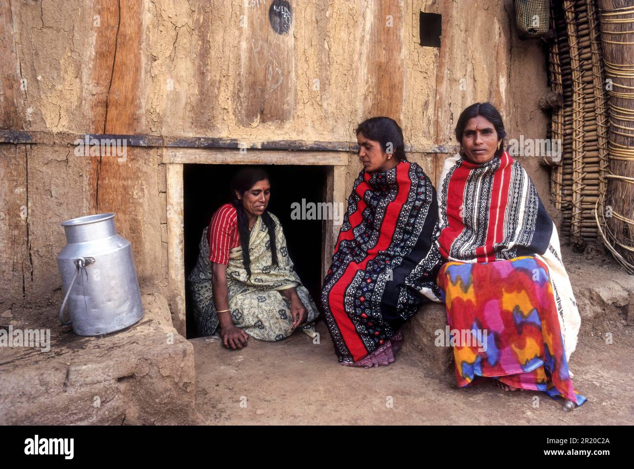 Toda tribe women in front of the hut, entry is through a carved wooden ...