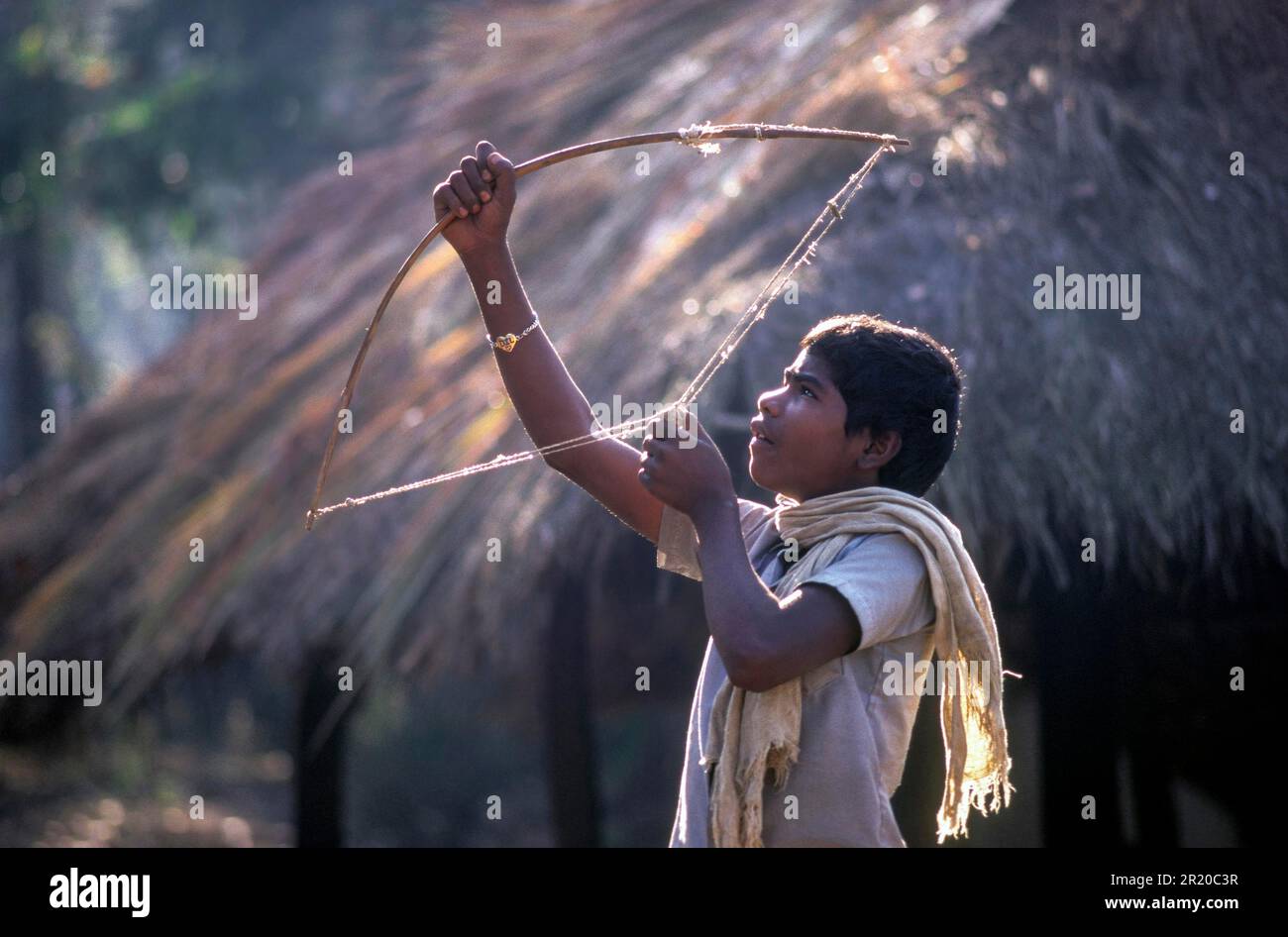 Jenu Kurumba tribal boy aiming with a stone, Nagarahole, Karnataka ...