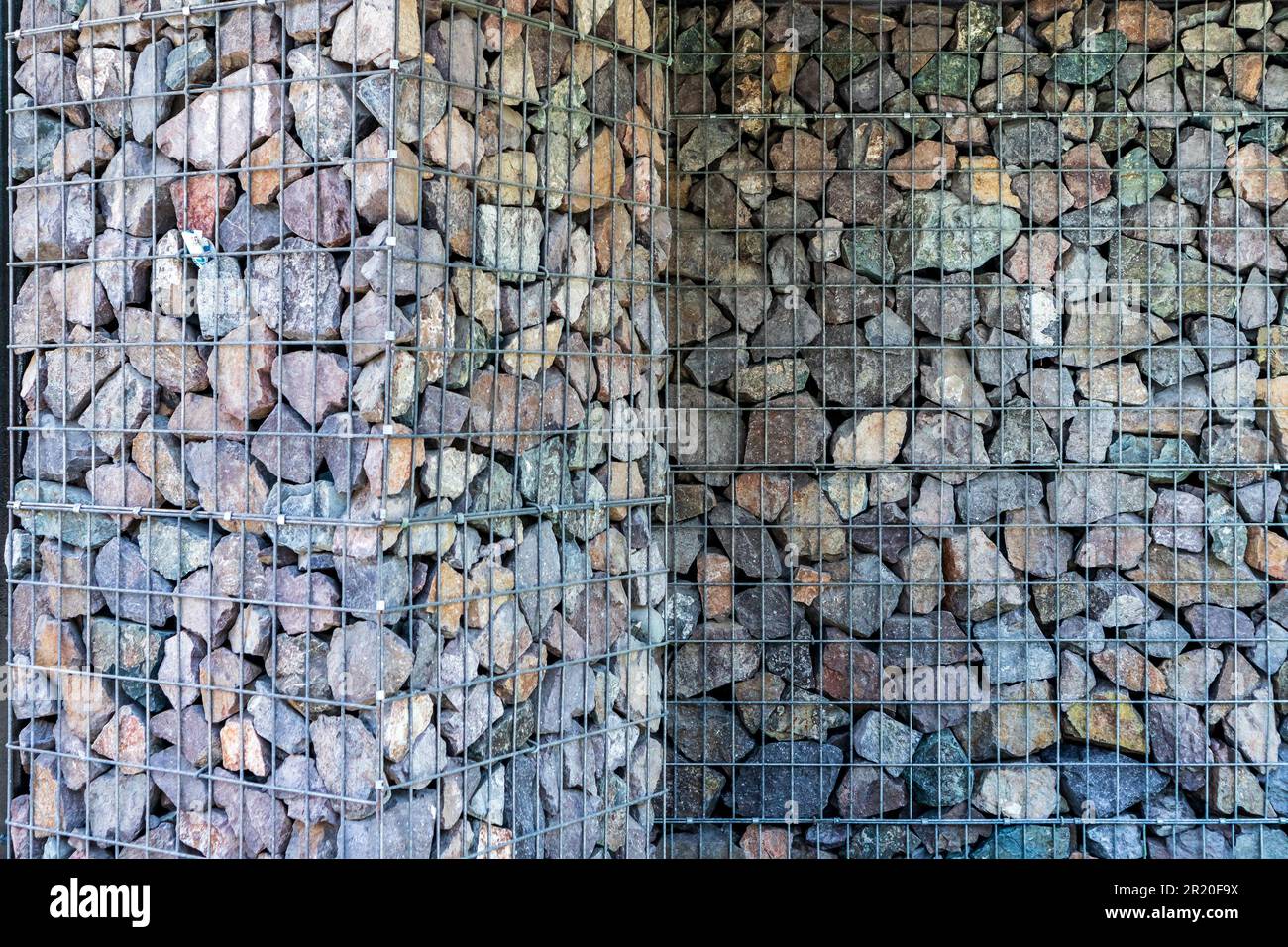 Plinth of a building on a slope lined with natural stone in the form of ...