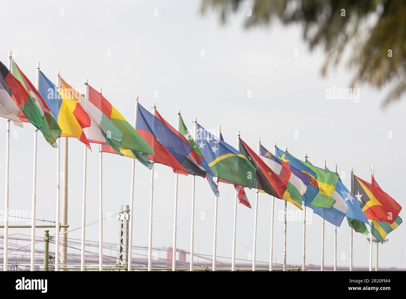 Flags of different countries flutter in the wind on the sky background ...