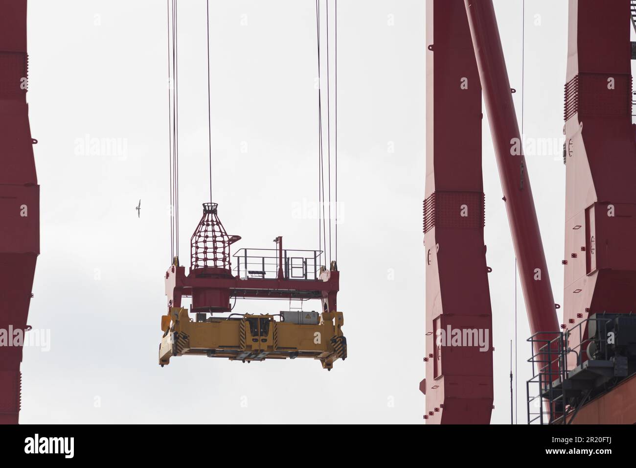 Sea port - lifting crane with spreader hanging in the air Stock Photo ...