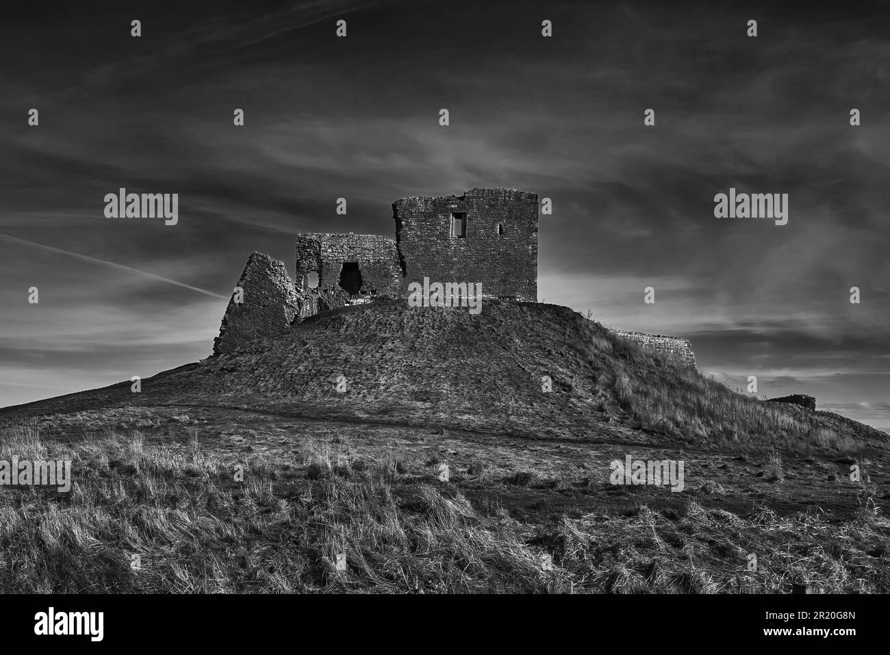 The ancient Duffus castle ruins atop a rocky hill, surrounded by clouds ...