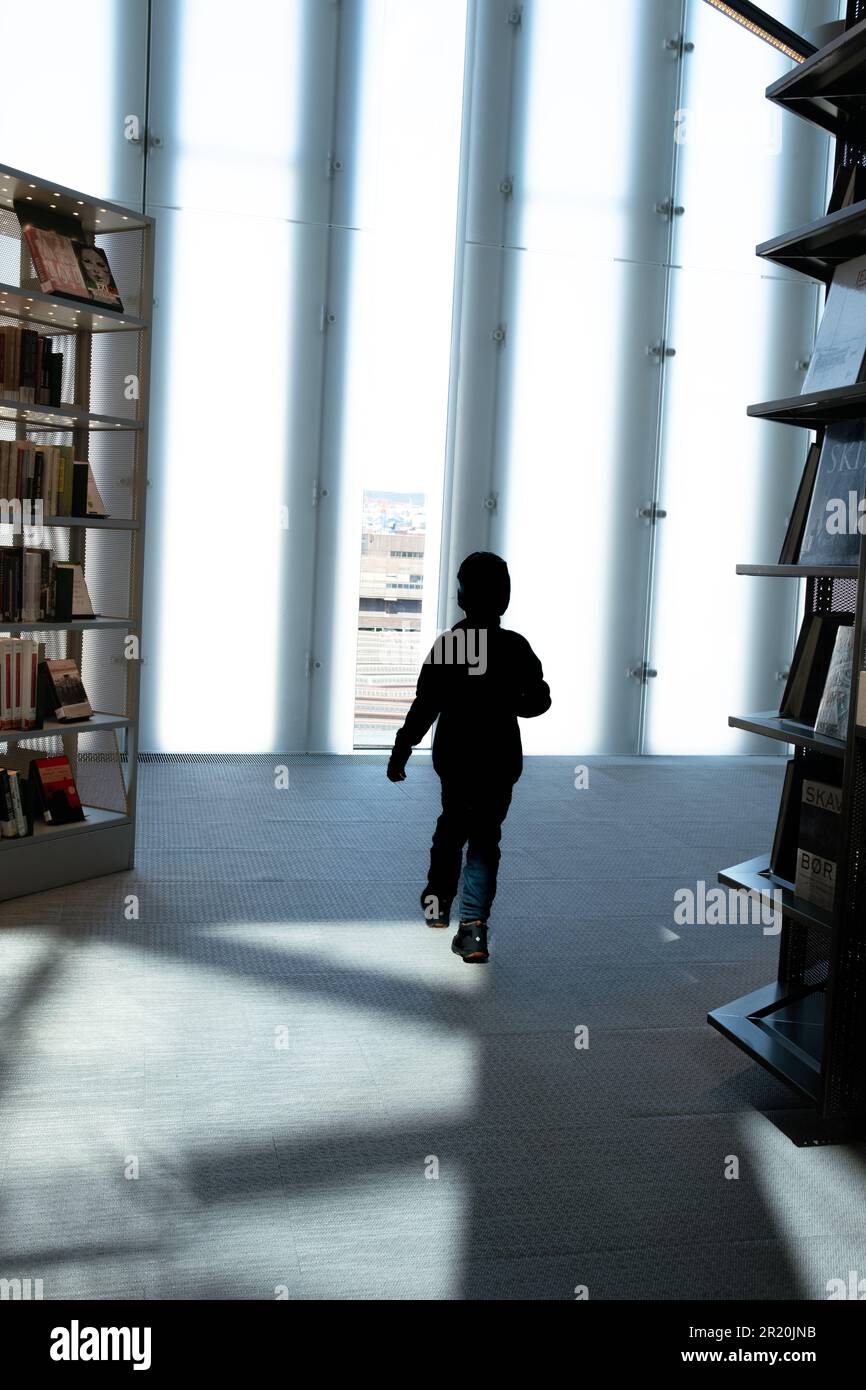 a silhouette of a child going around the library Stock Photo - Alamy