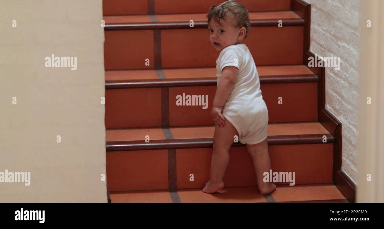 Baby climbing and standing on home stairs Stock Photo - Alamy
