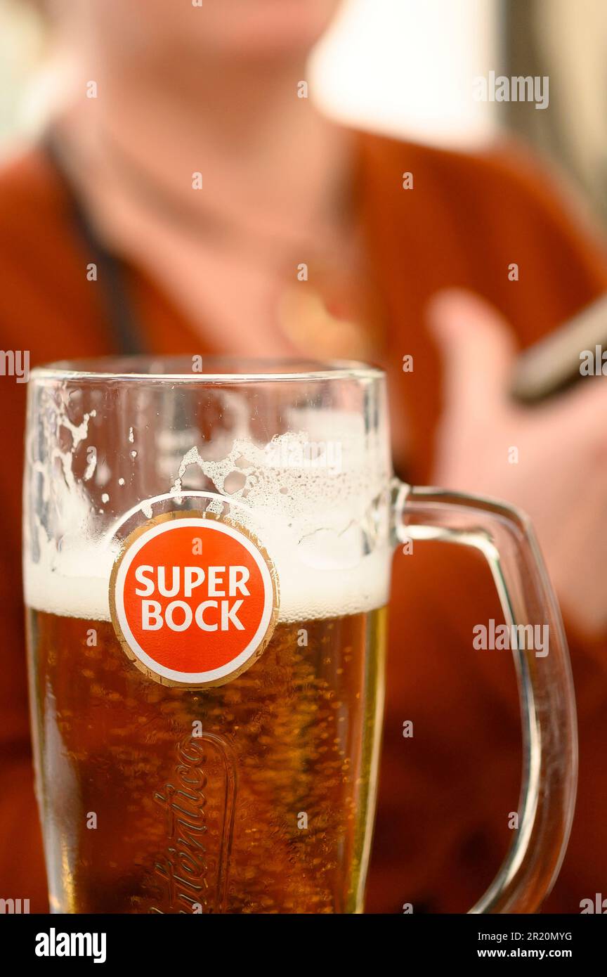 Lisbon, Portugal - April 30, 2023: A tourist enjoying a Super Bock beer ...