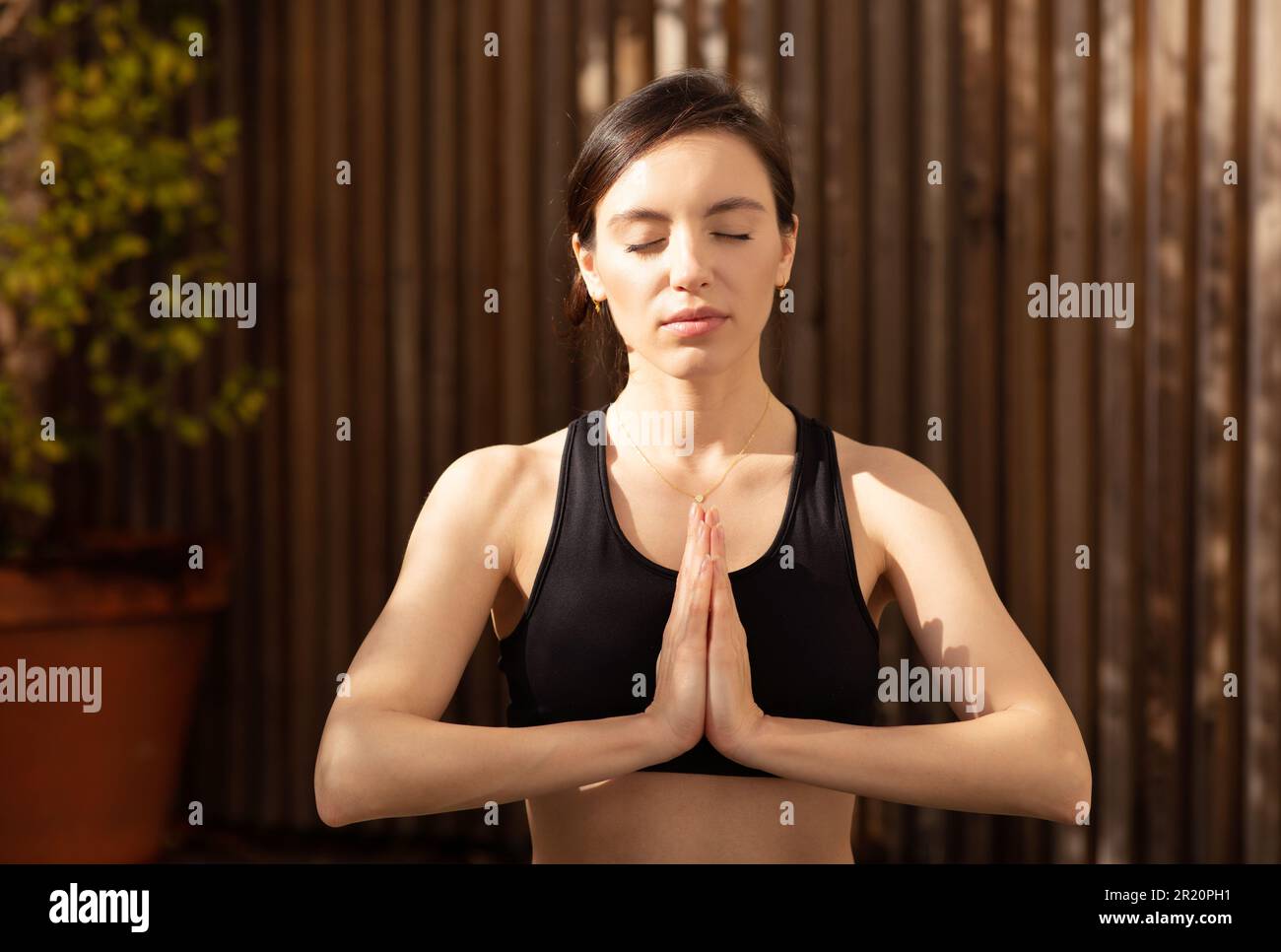 Serious calm young caucasian slim lady practices yoga, enjoys workout ...