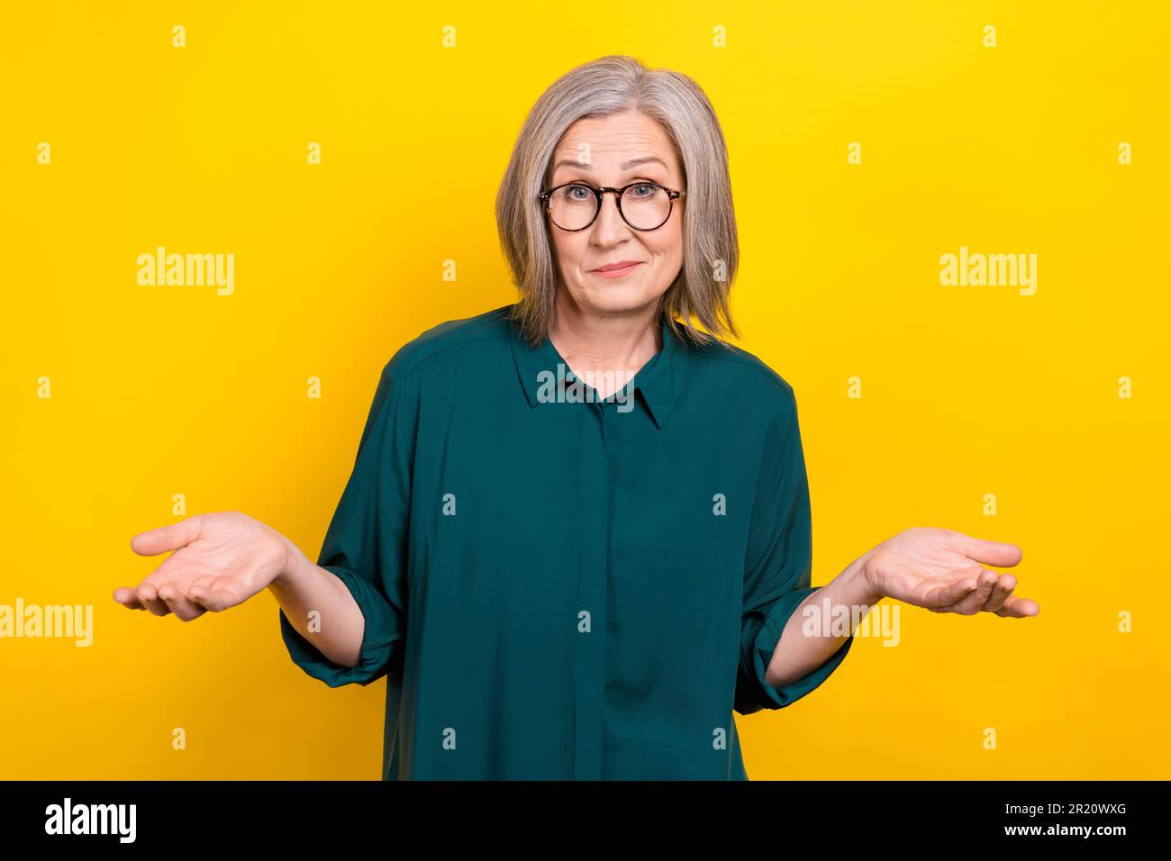 Photo of questioned puzzled marketer aged lady shrugging shoulders not ...