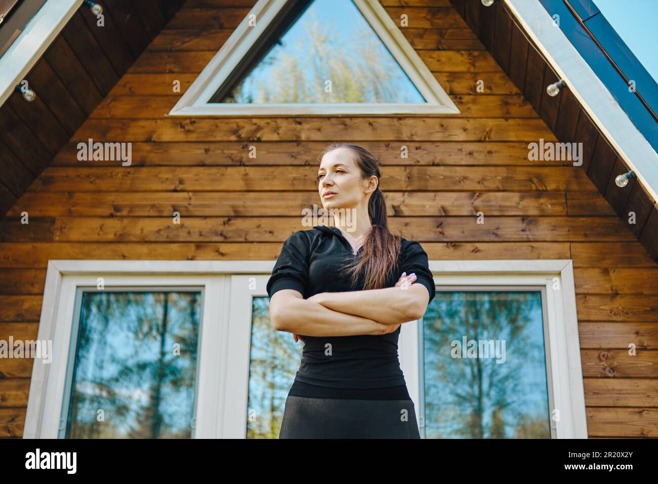 Athletic woman standing with her arms crossed on her chest (low angle ...