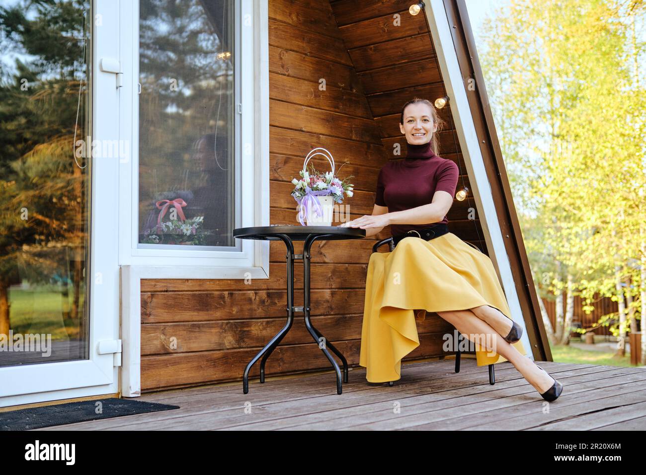 Happy smiling woman resting on terrace of tiny house Stock Photo - Alamy
