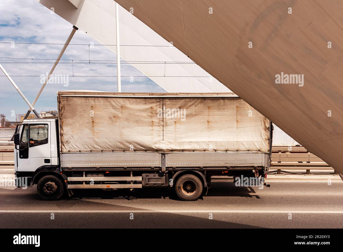Transportation and logistics, old truck with dirty tarp crossing the ...