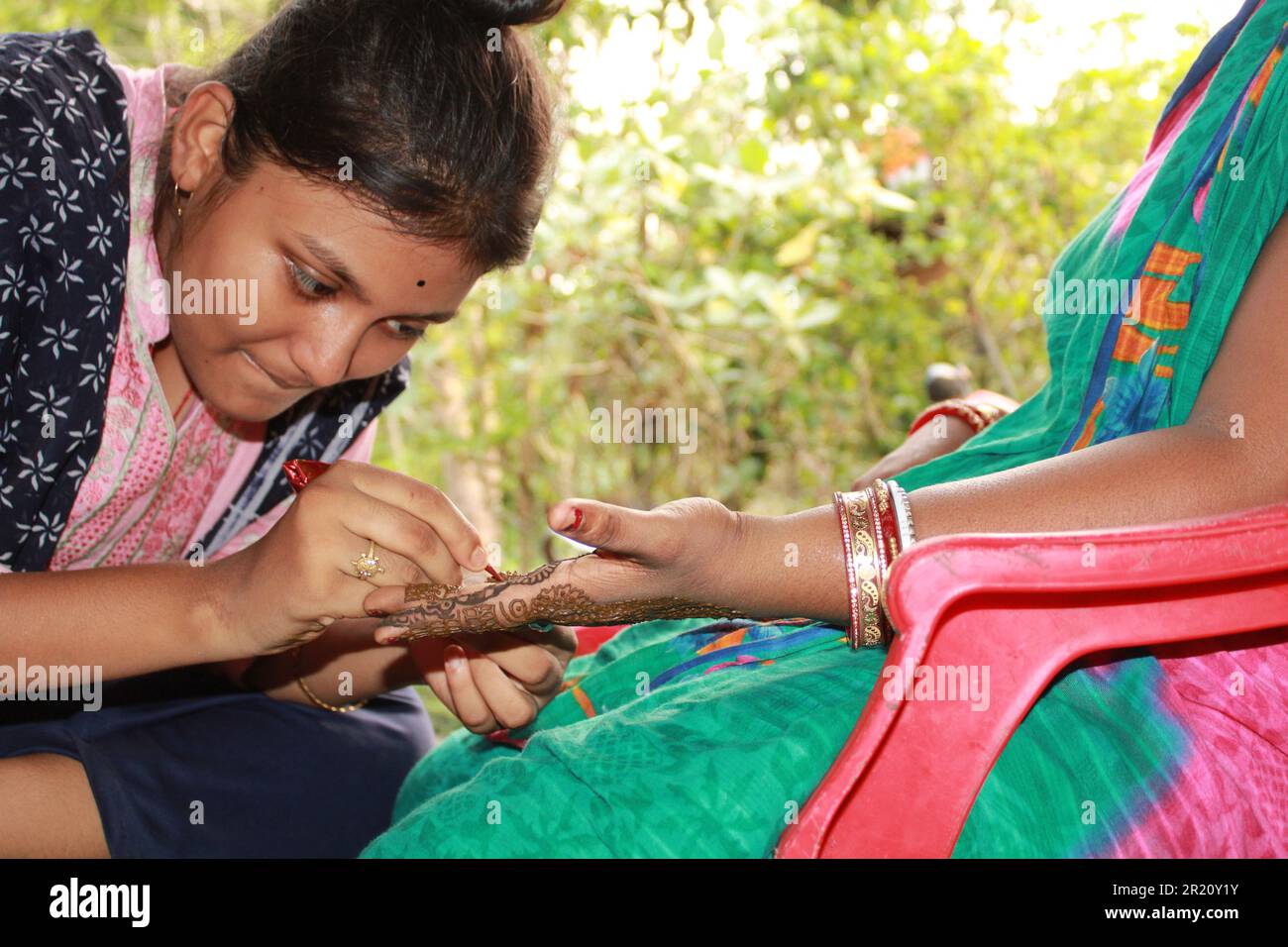 Indian Teenage Girl Applying Heena Tatoo On Woman's Hand Stock Photo ...