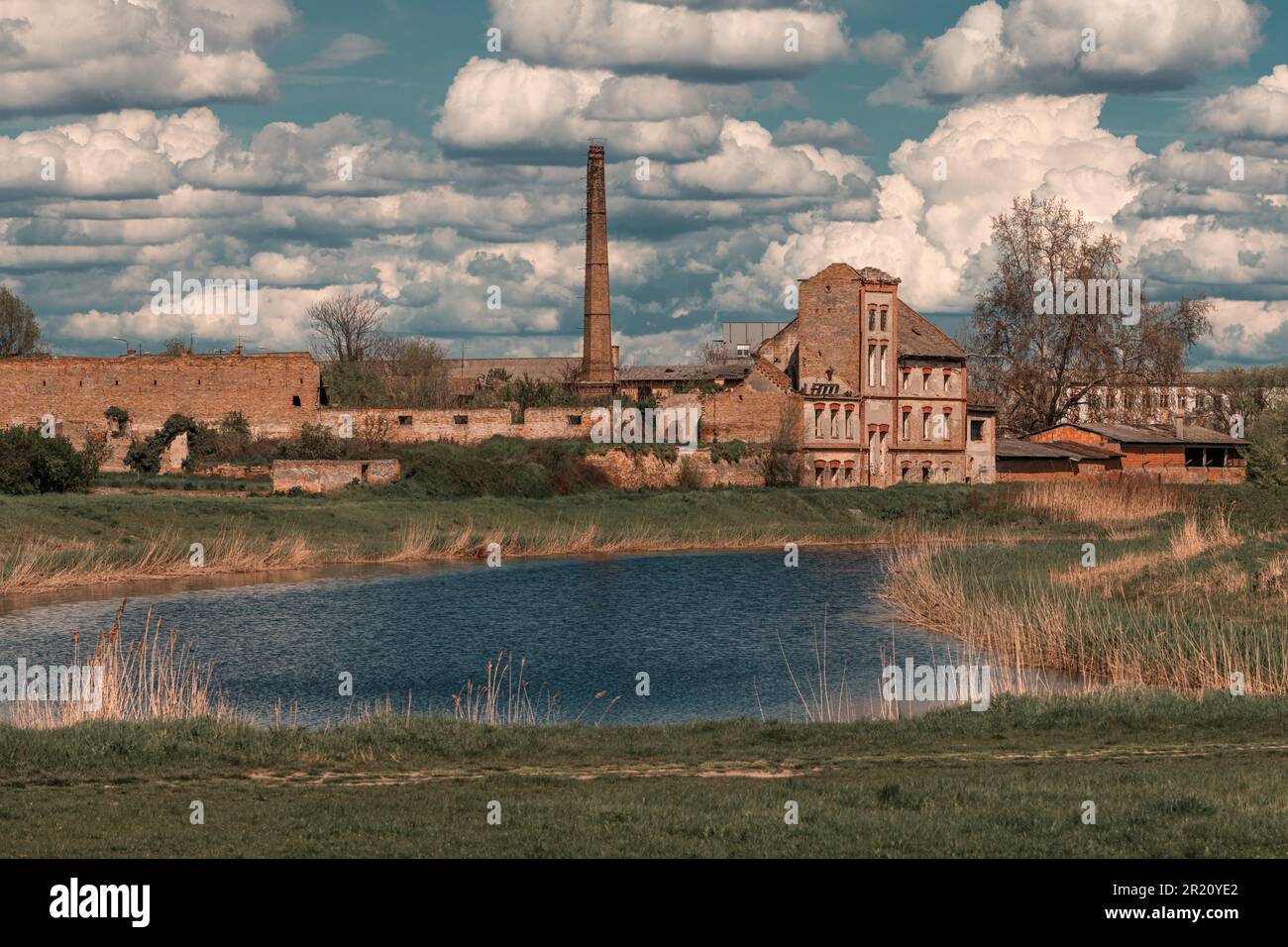 Old ruined factory building at lakeside on sunny spring day, selective ...