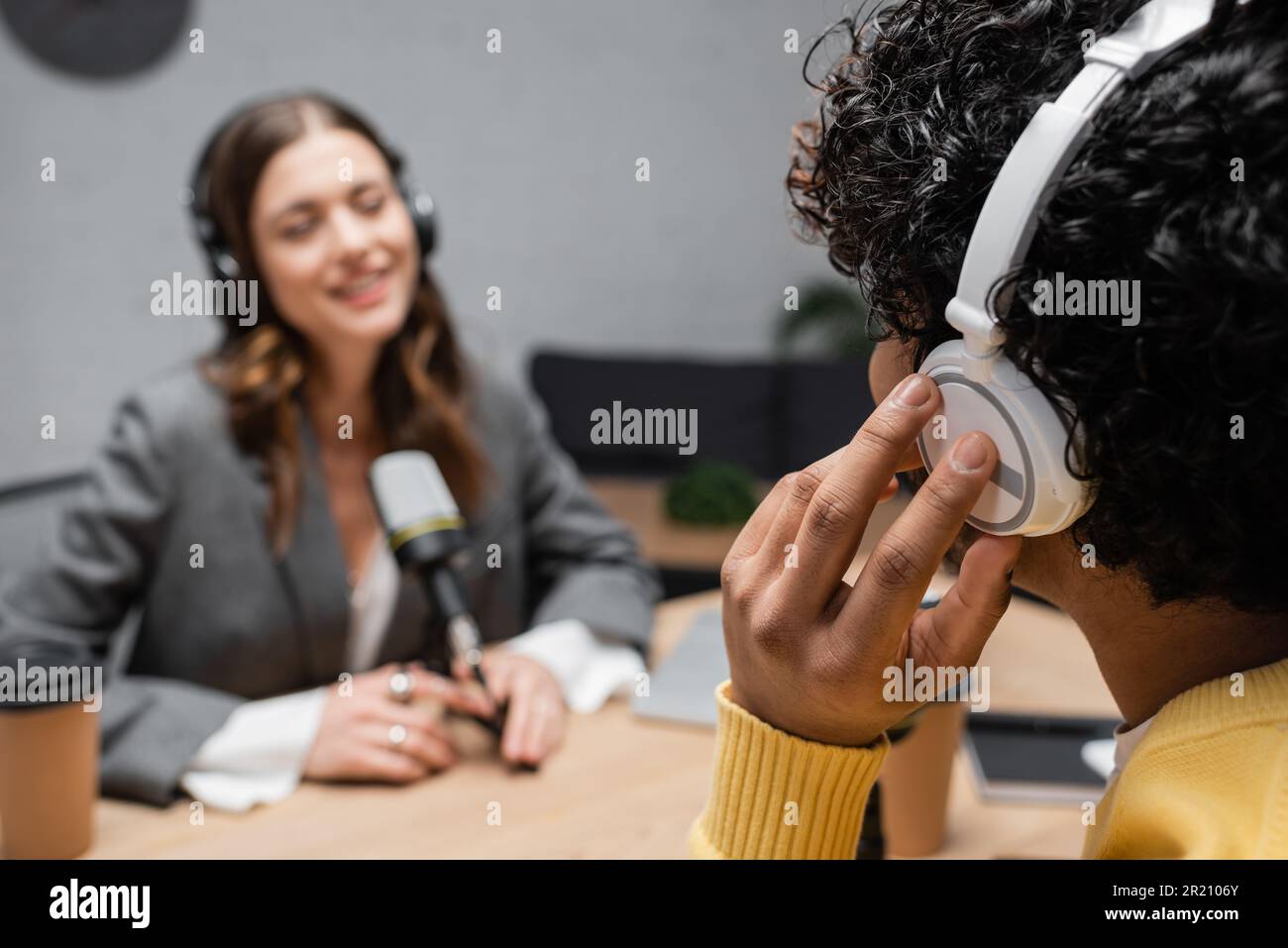 young indian man adjusting headphones during interview with blurred ...