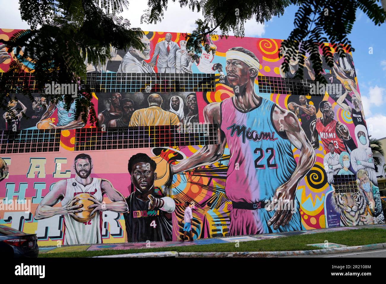 Artist Kyle Holbrook walks past his mural featuring Miami Heat players ...