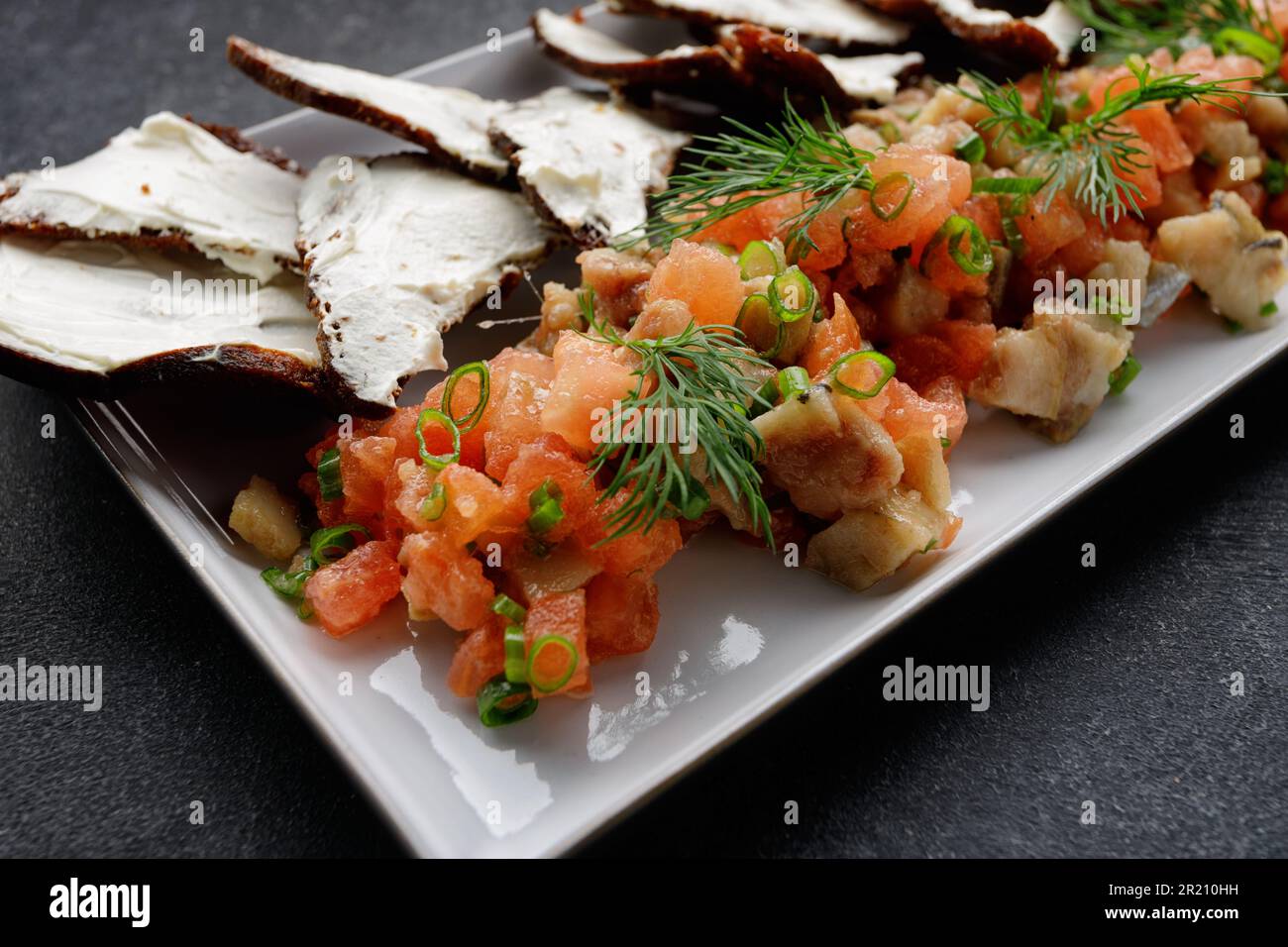 flavorful salmon and mixed fish tartare paired with toasts with butter ...