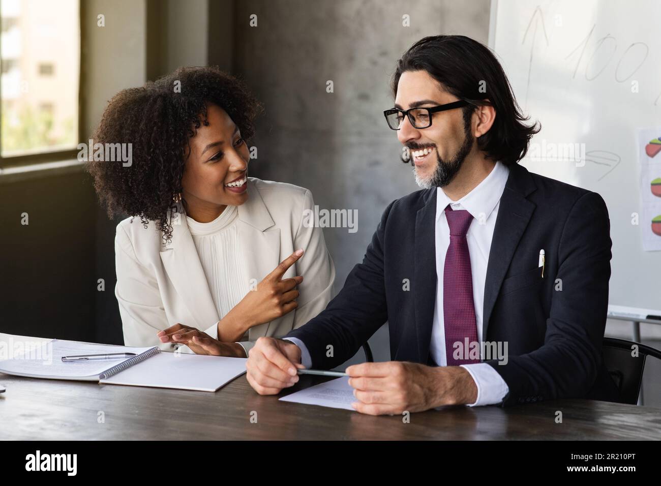 Cheerful multicultural colleagues have conversation during work meeting ...
