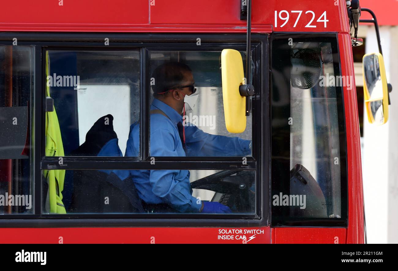 Photograph of a London bus driver during the Covid-19 pandemic. He is ...
