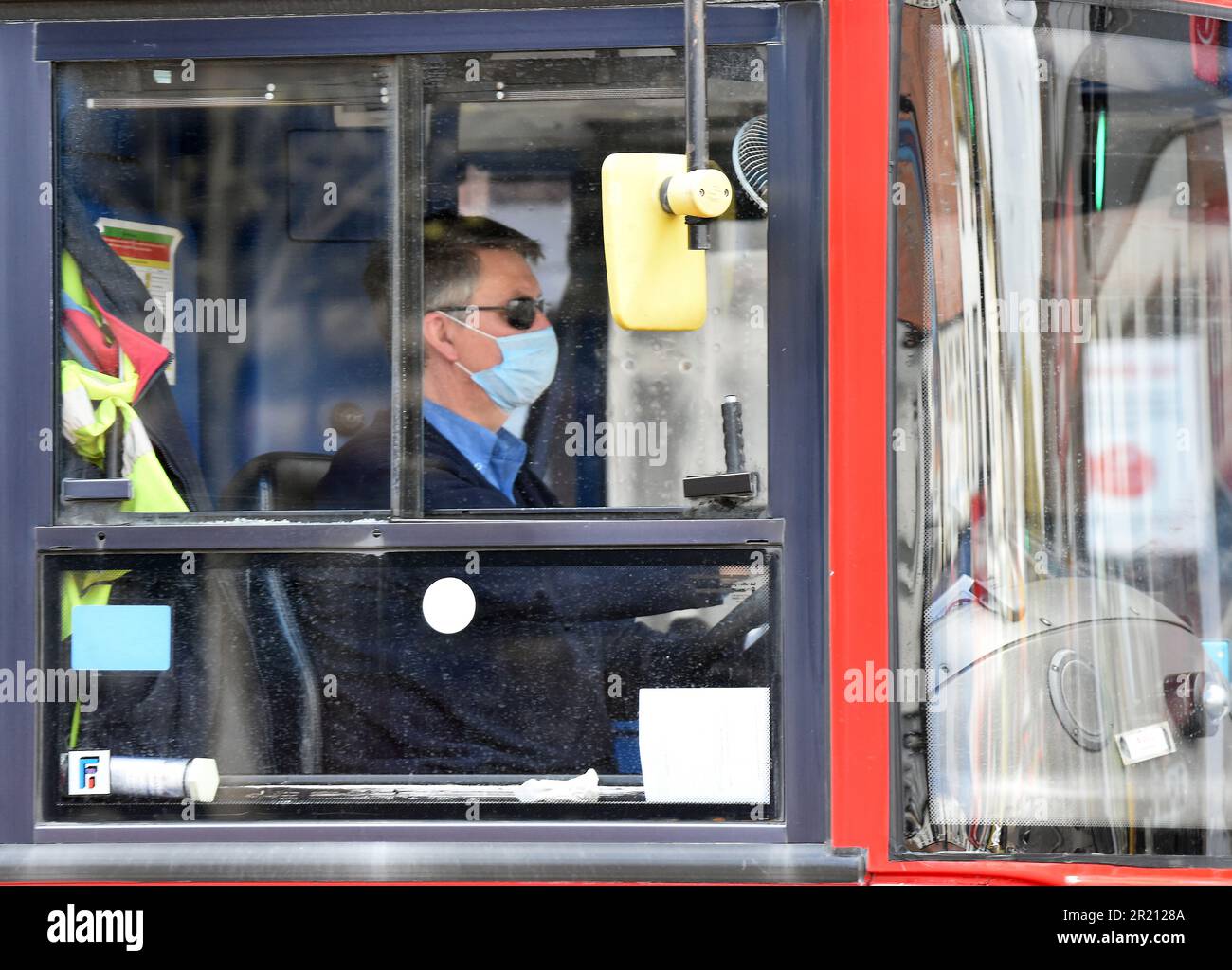 Photograph of a London bus driver during the Covid-19 pandemic. He is ...