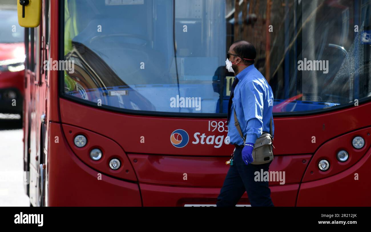 Photograph of a London bus driver during the Covid-19 pandemic. He is ...