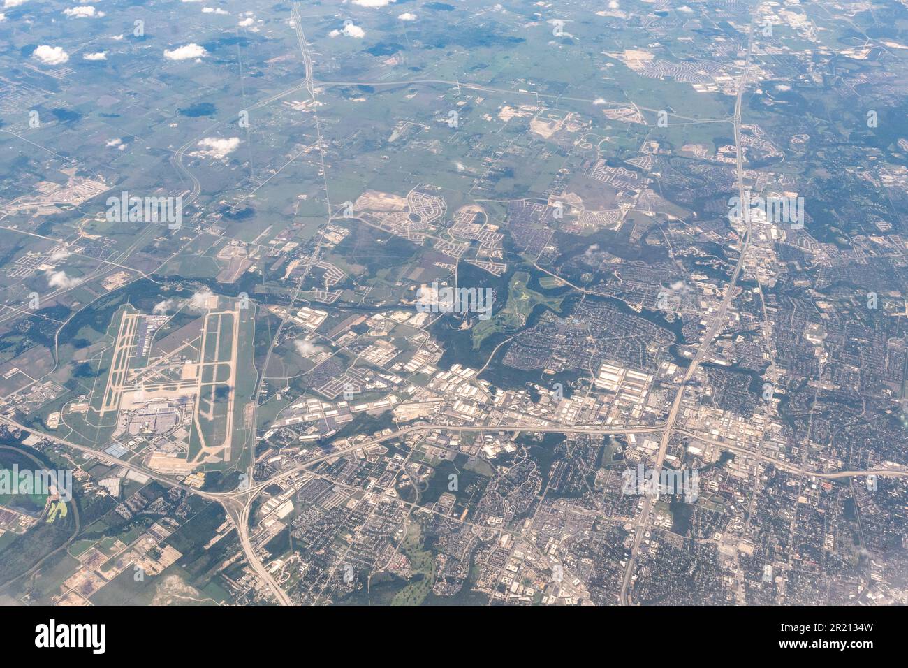 Aerial view of an airport and a smaller city in the midwestern United ...