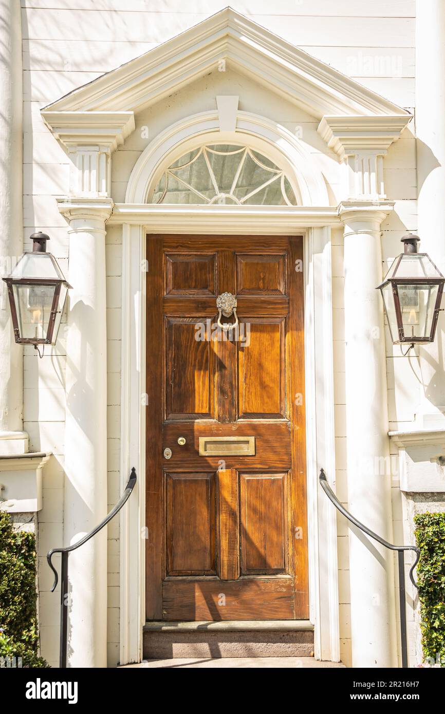 A colonial style front door with an eccentric door frame in sunlight ...