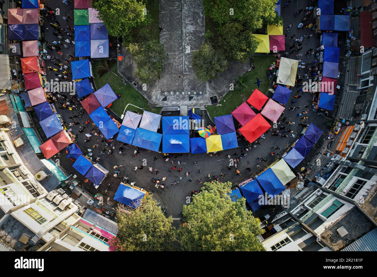 A circular cityscape depicting a large street with several tents in ...