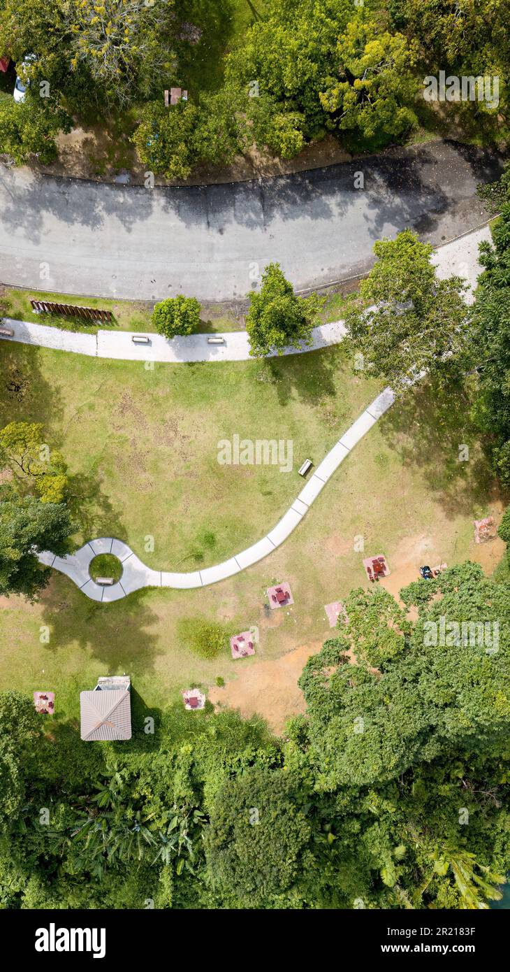 Aerial view of a road surrounded by benches and trees, with a sunny sky ...
