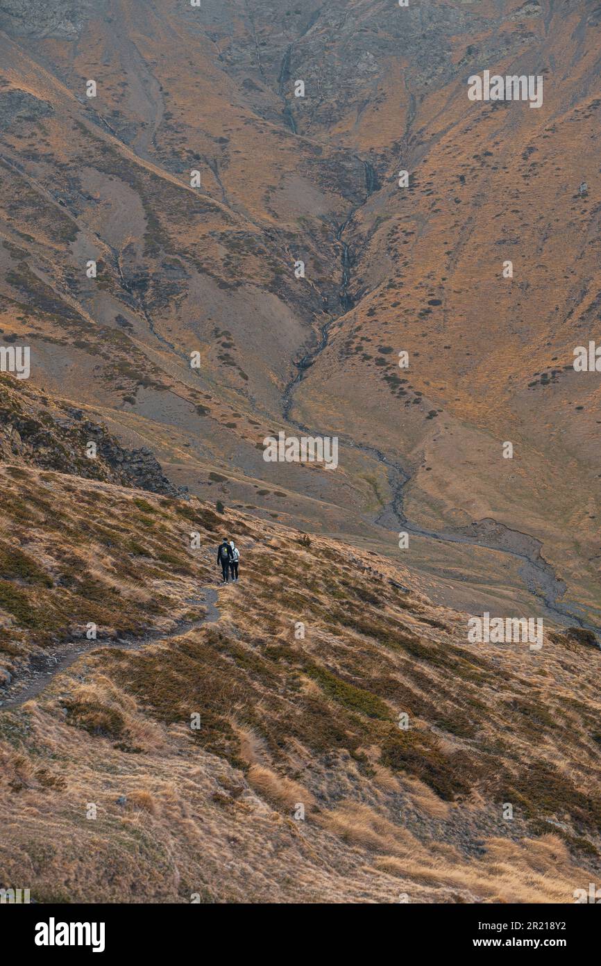 Vertical shot Tourists descend the high mountain ranges of the Pyrenees ...