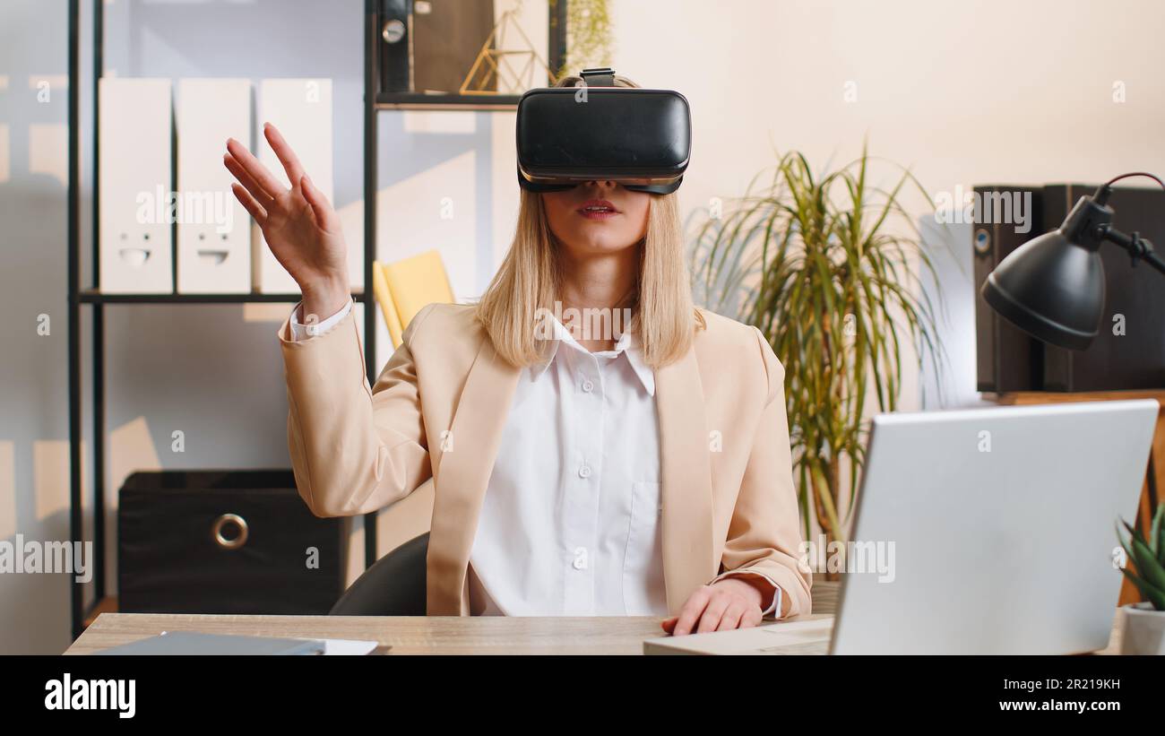 Business woman using virtual reality futuristic technology VR app ...