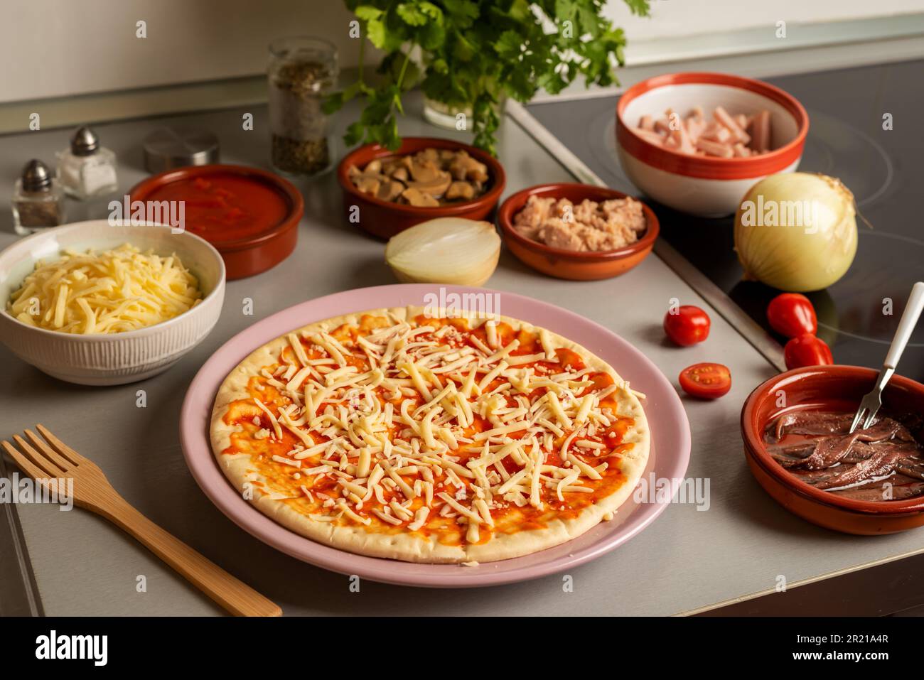 Preparing pizza in the kitchen at home, with its typical ingredients ...