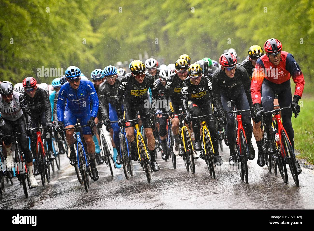 The pack of riders pedals under the rain during the 10th stage of the ...