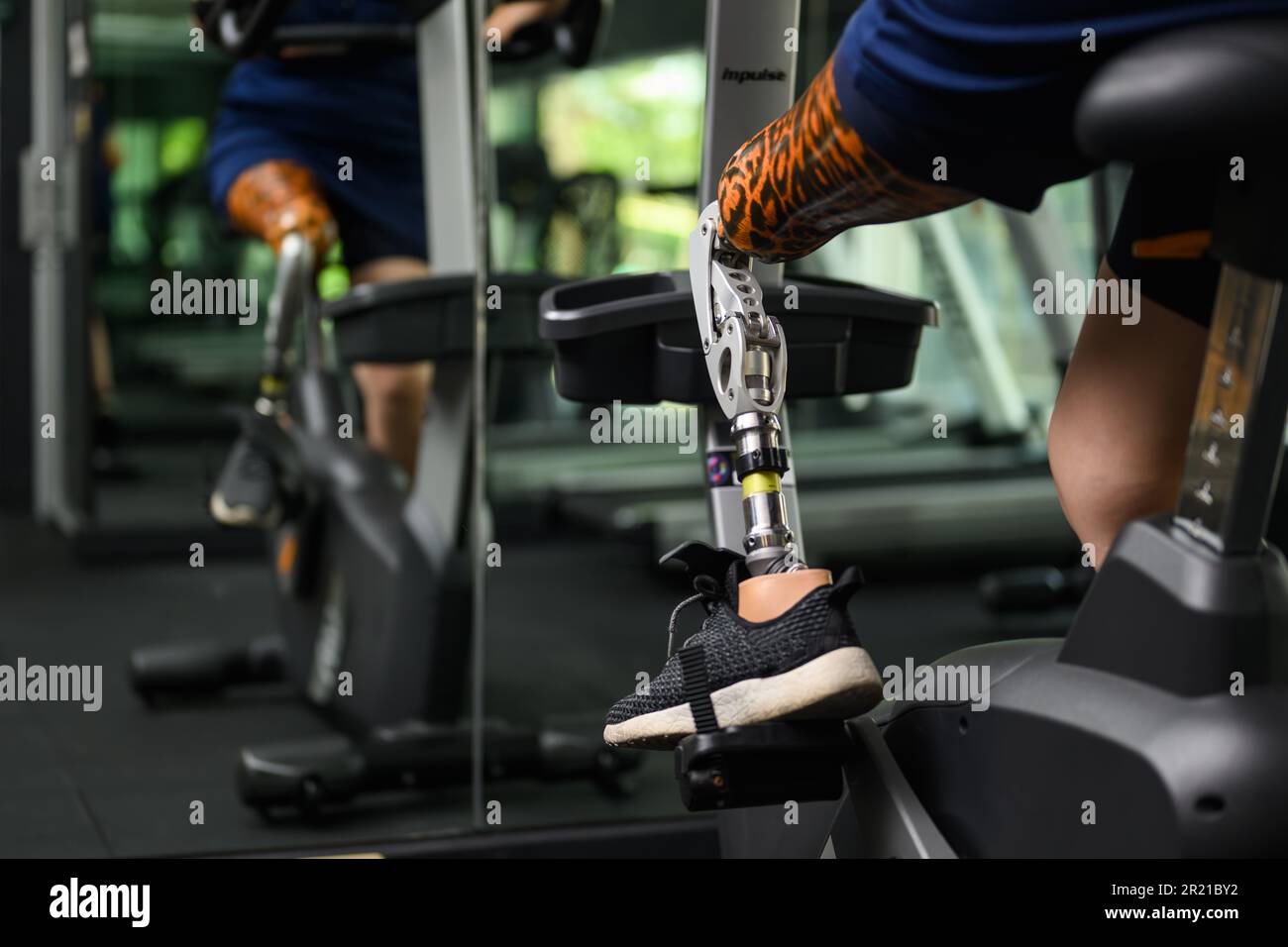 Disabled athlete patient with prosthetic leg doing exercise at gym ...