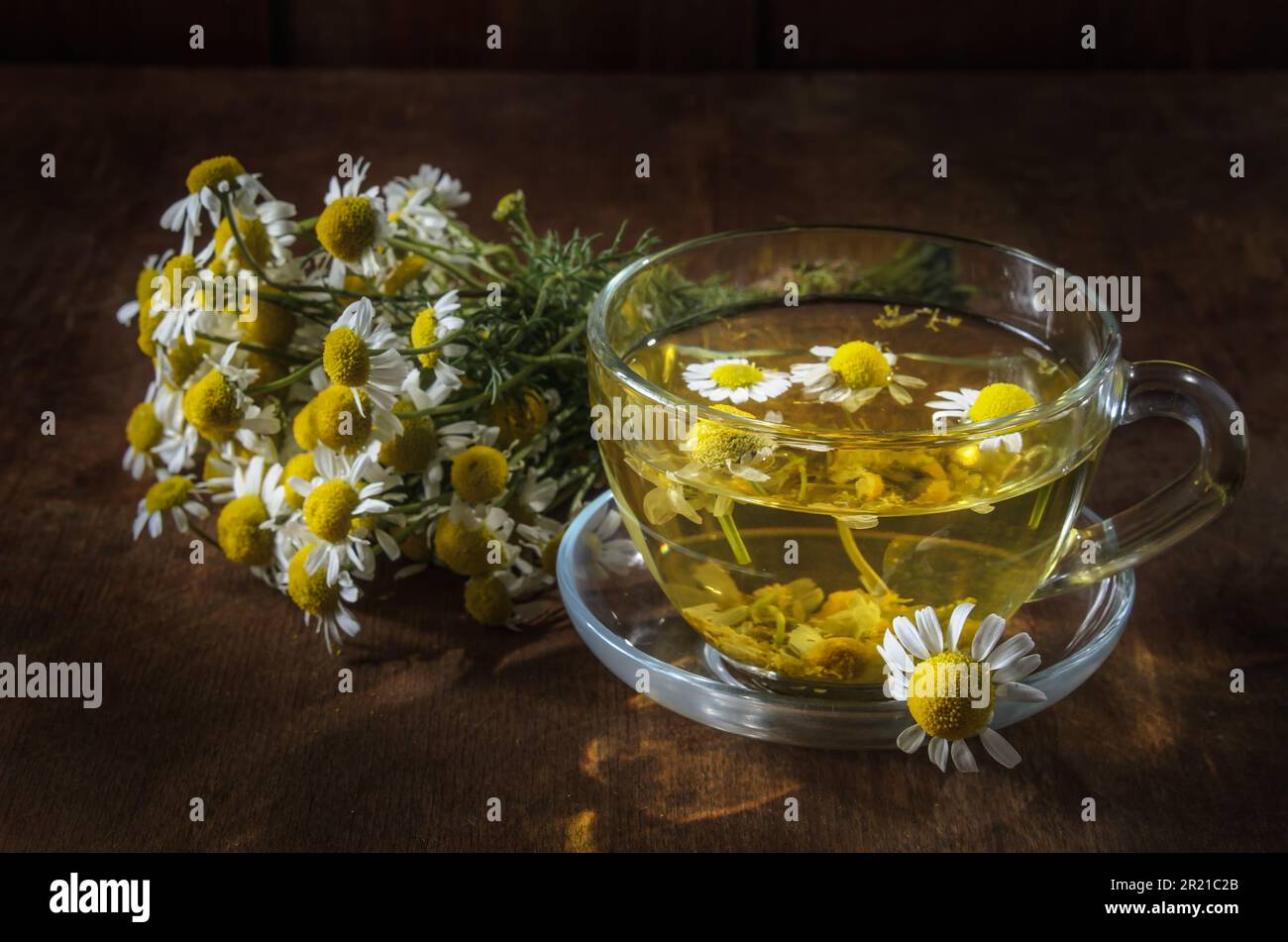 herbal tea cup and daisy medicinal herbs bunches on wooden board Stock ...