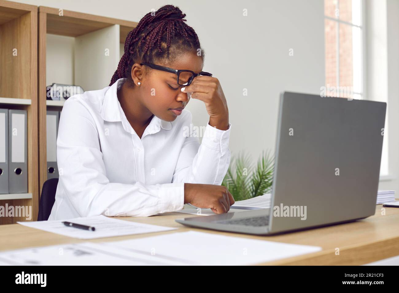 Stressed tired overworked office worker suffering from eye strain ...
