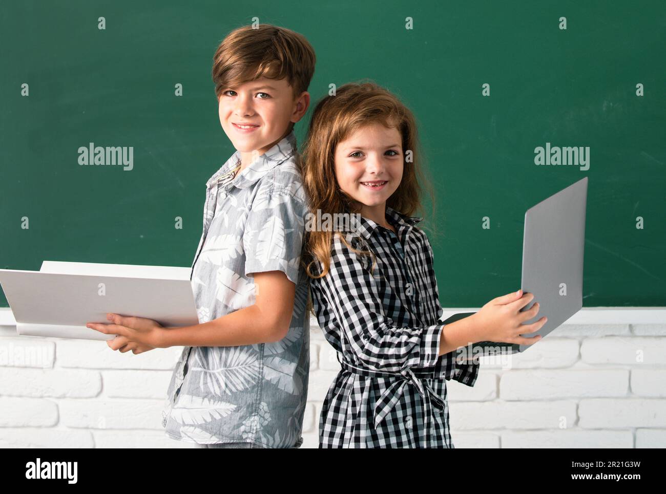 Elementary school kids. Portrait of children boy and girl with laptop ...