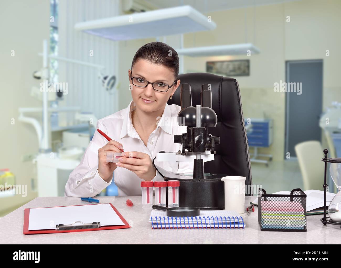 female medical or scientific researcher studying the sample container ...